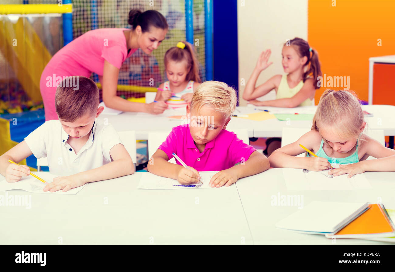 smiling children sitting together and studying in class at school Stock ...