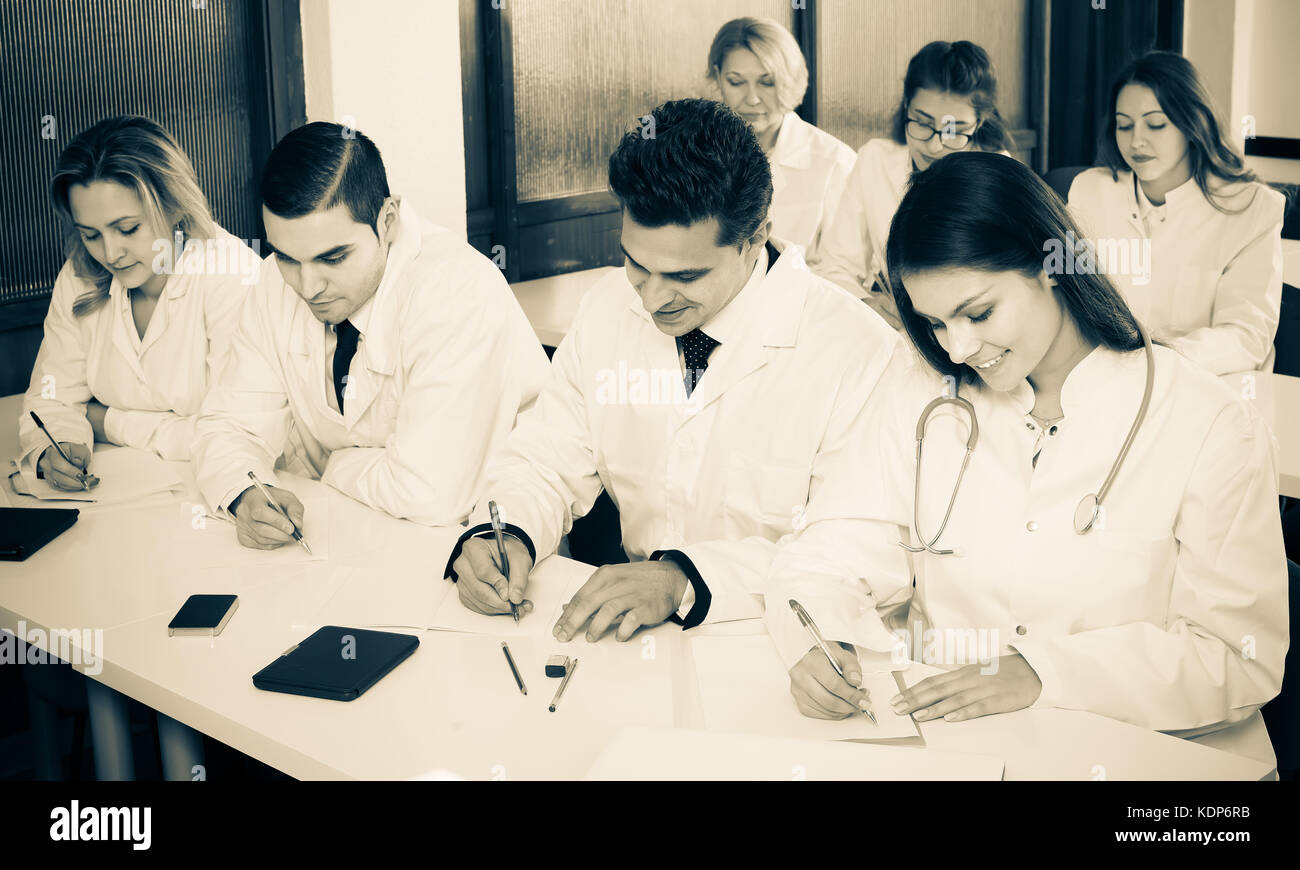 Group of smiling scientists in white uniform at advanced training ...