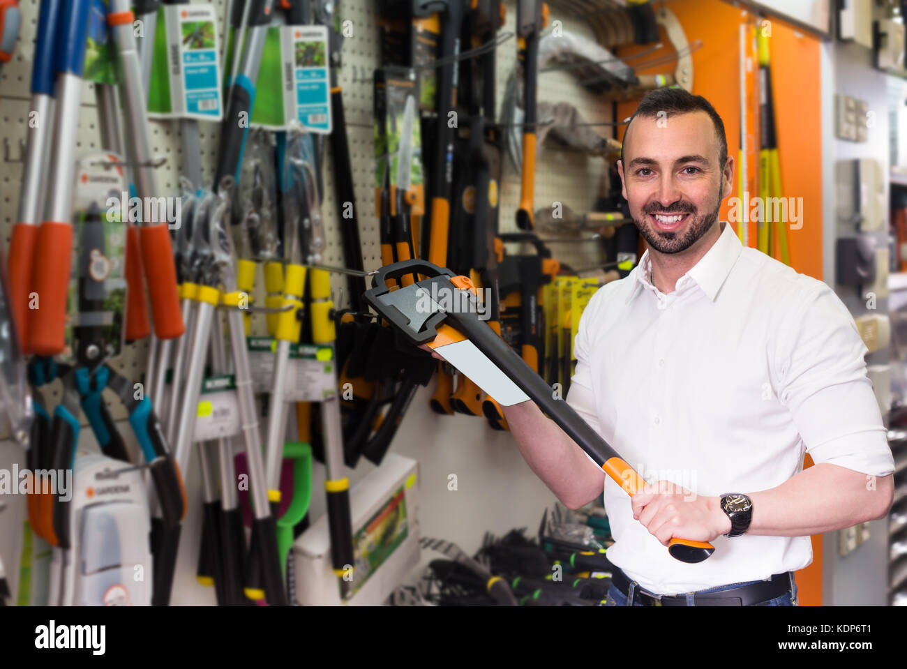 smiling man choosing big hacker in household shop Stock Photo - Alamy