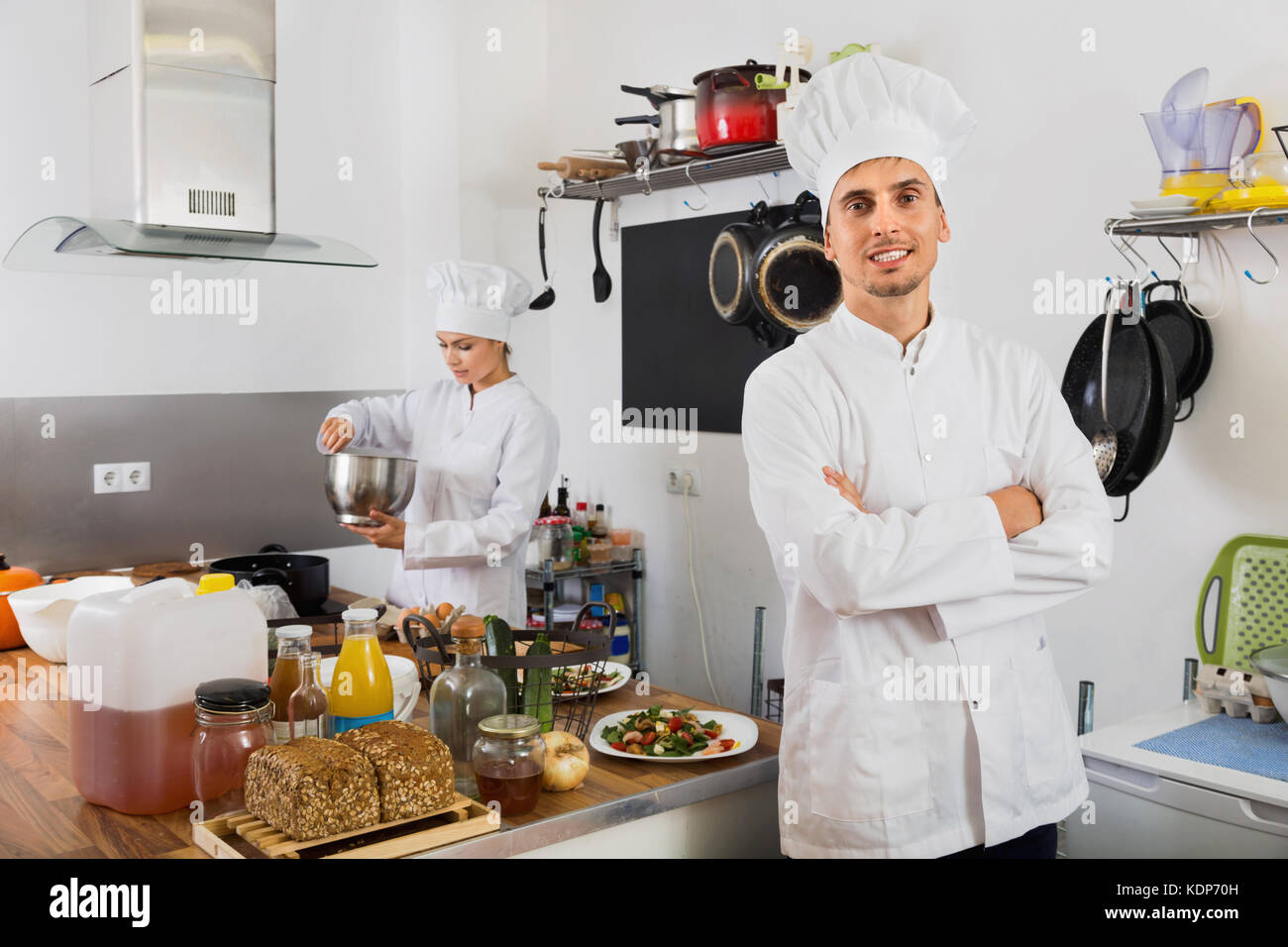 Cheerful friendly happy male young cook wearing uniform working on ...