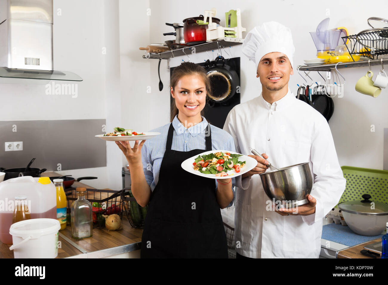 friendly smiling cook in uniform standing with waitress and served ...