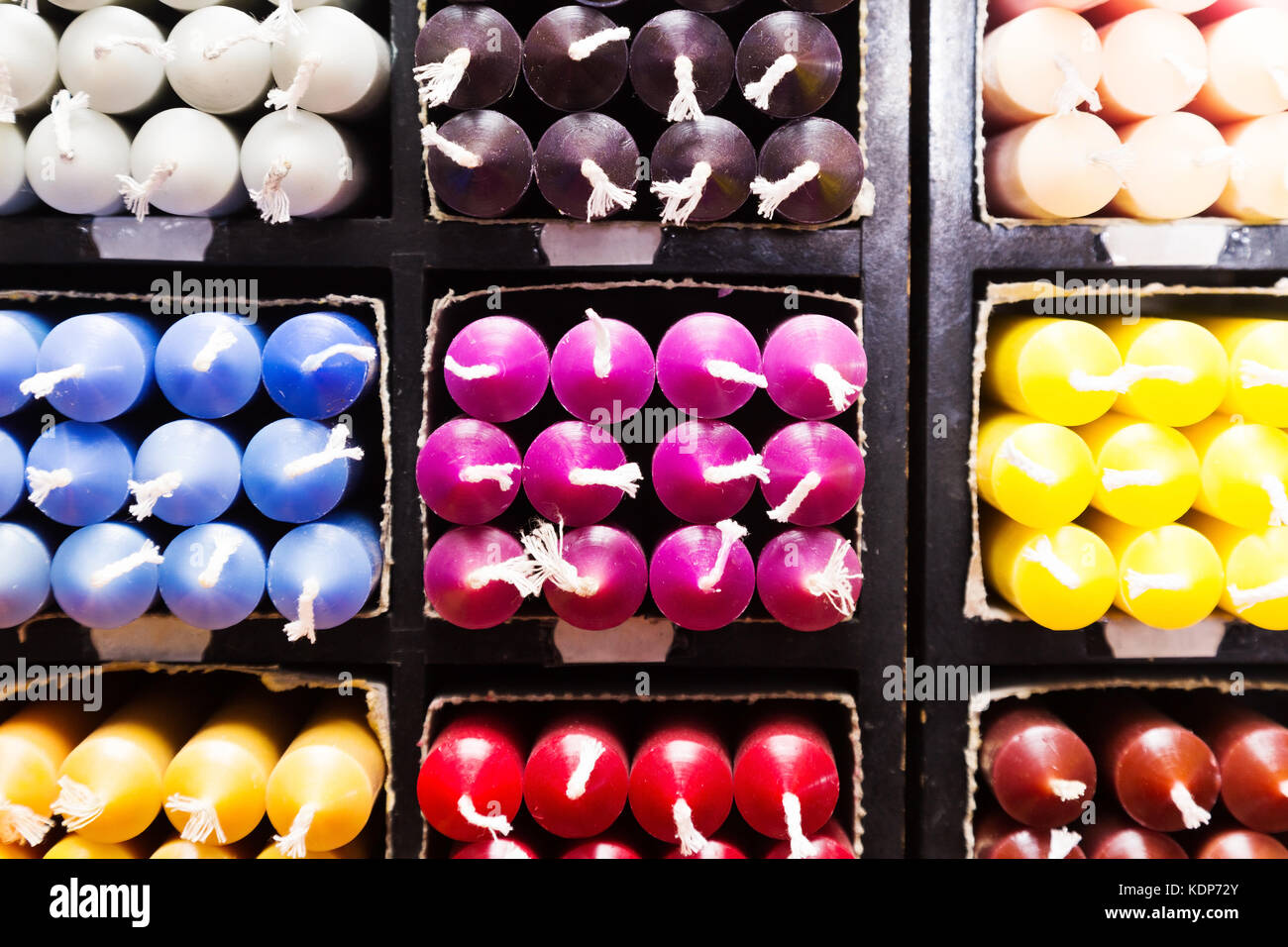 closeup view on multicolored candles sorted by color on shelf in store ...