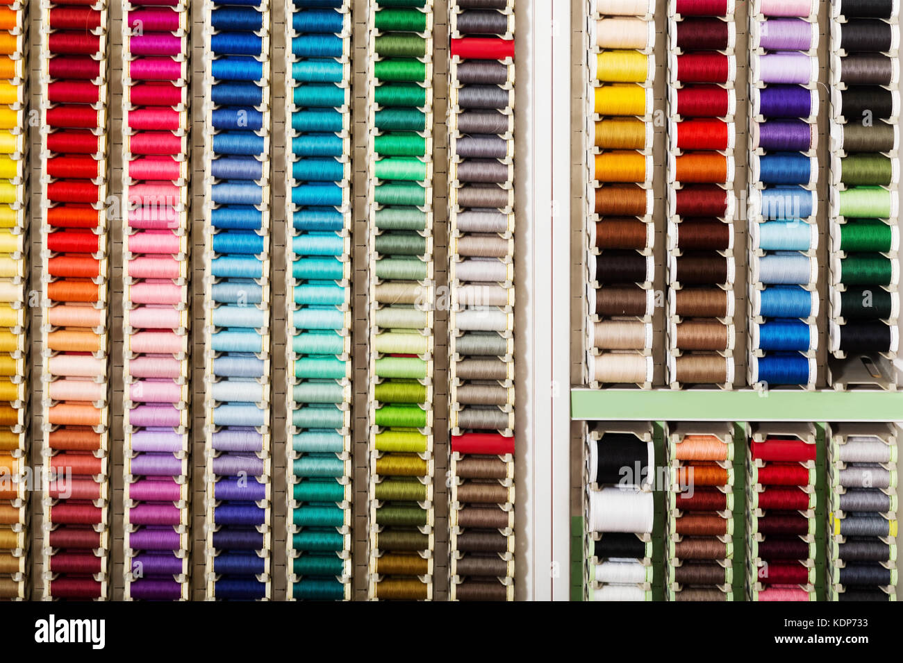 sewing threads in different bright colors in shop Stock Photo - Alamy