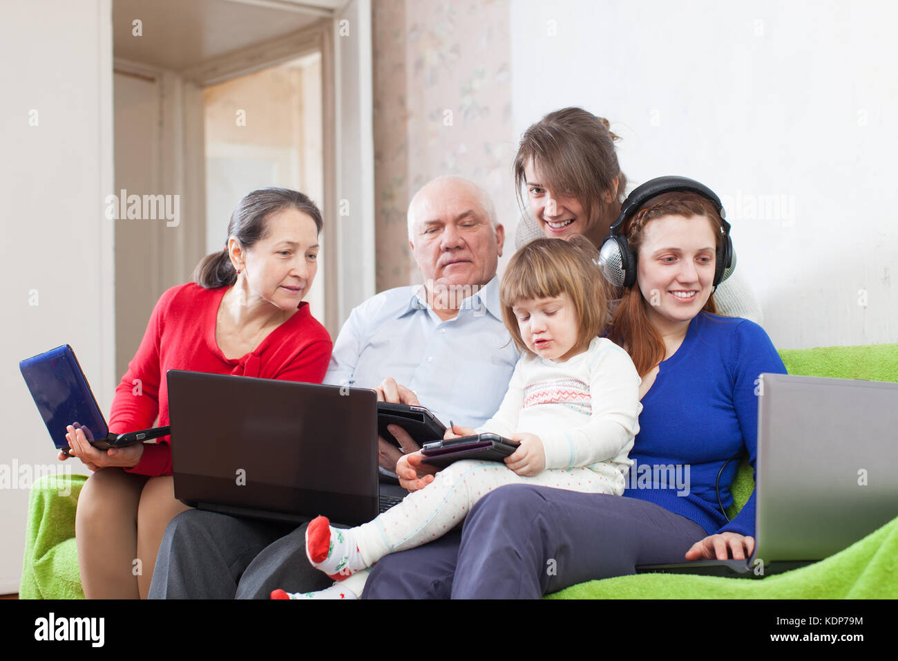 family of three generations uses few various devices in home Stock ...
