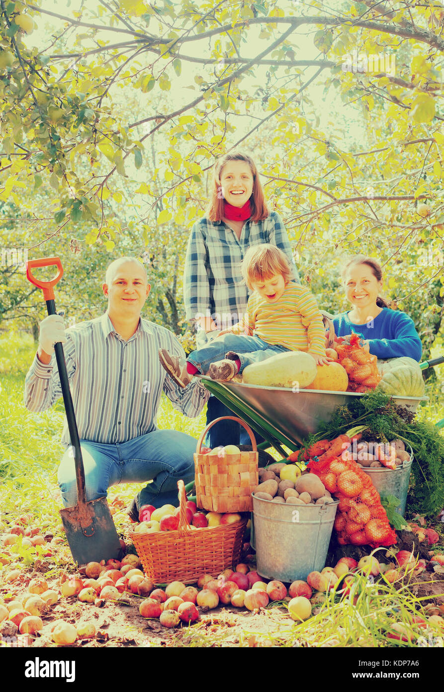 Happy family with vegetables harvest in garden Stock Photo - Alamy