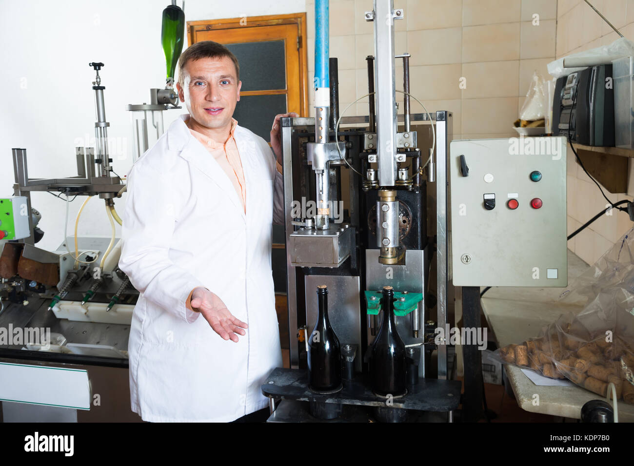 positive male assembly line operator working in modern wine factory ...