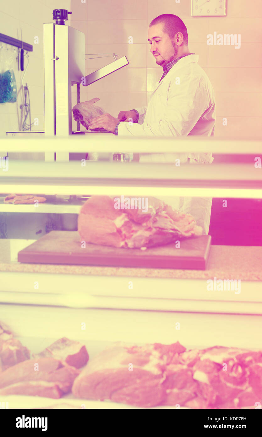 Male shop staff 35s selling halal meat at counter and smiling Stock ...