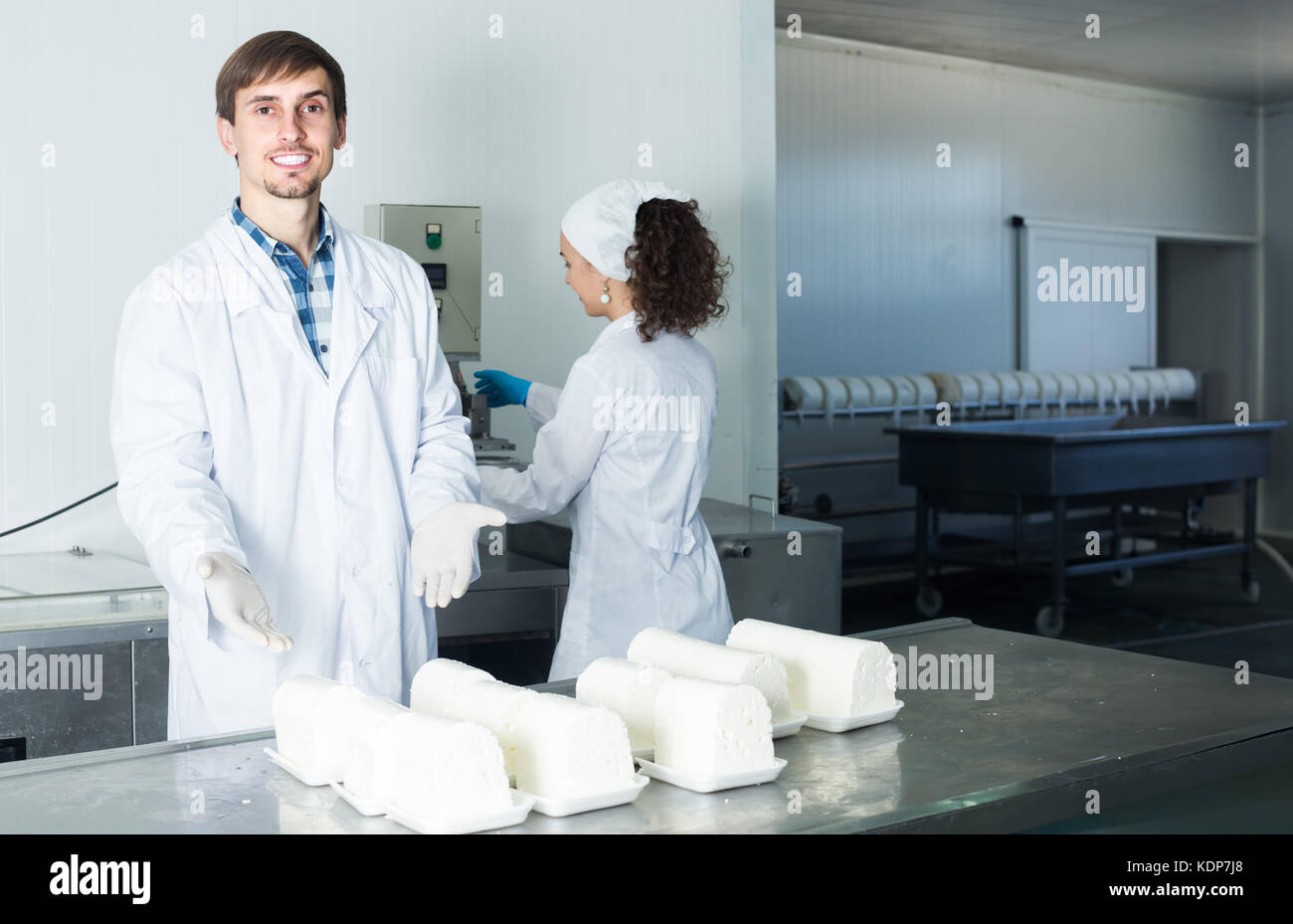 Two cheerful technologists in lab coats showing their production hi-res ...