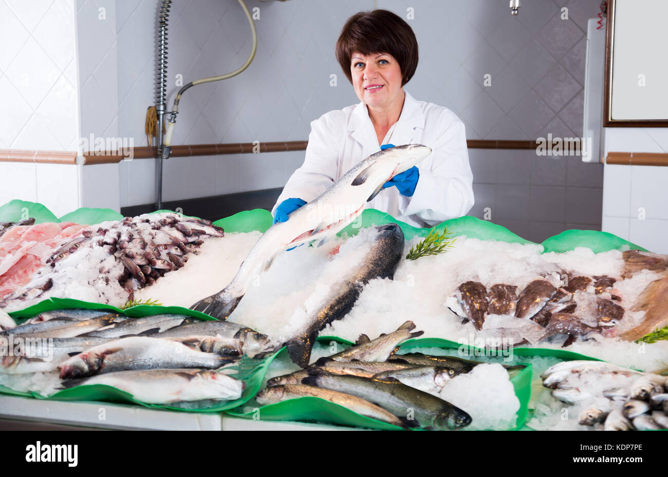Woman selling chilled fish and seafood in store Stock Photo - Alamy
