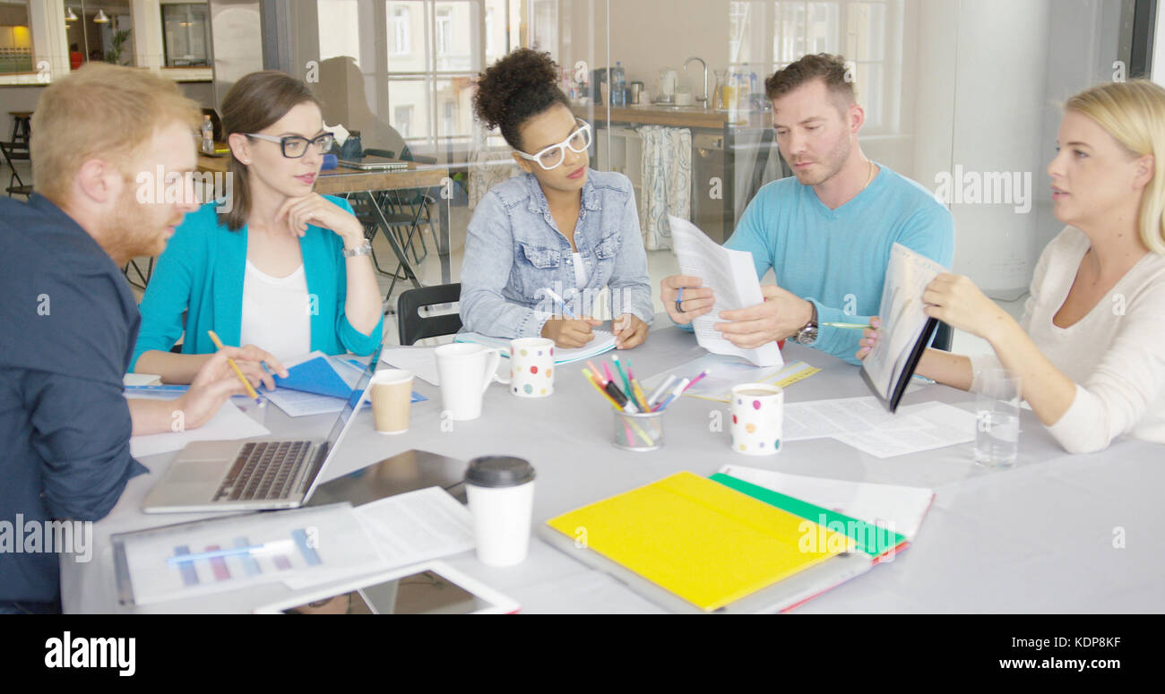 Woman showing documents to coworkers Stock Photo - Alamy