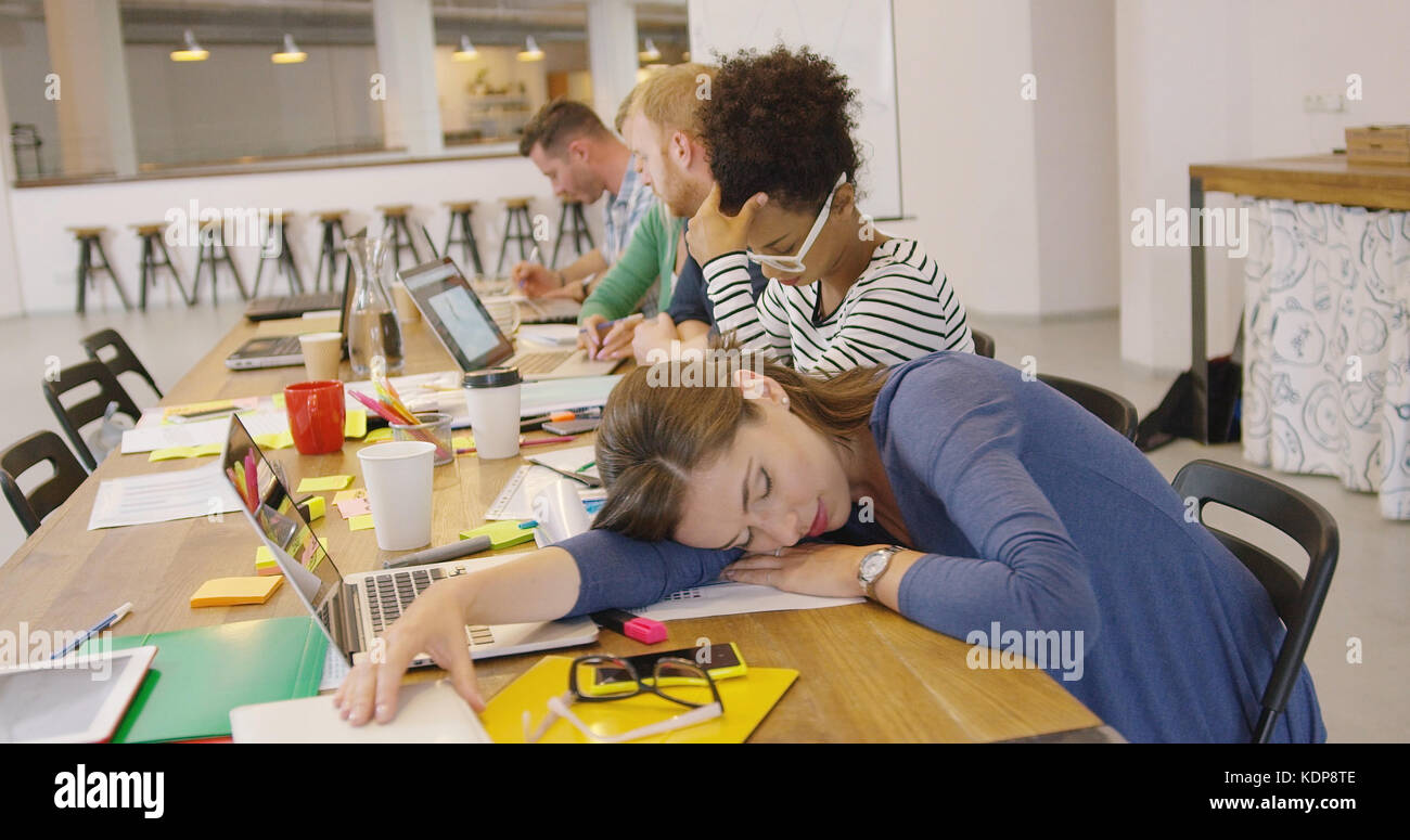 Tired worker at table in office Stock Photo - Alamy