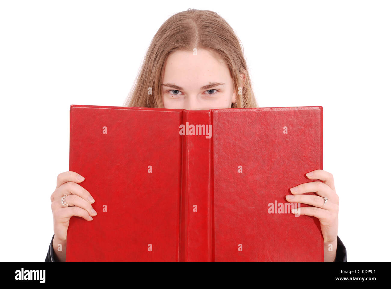 Beautiful school girl peeping from behind her red book isolated on ...