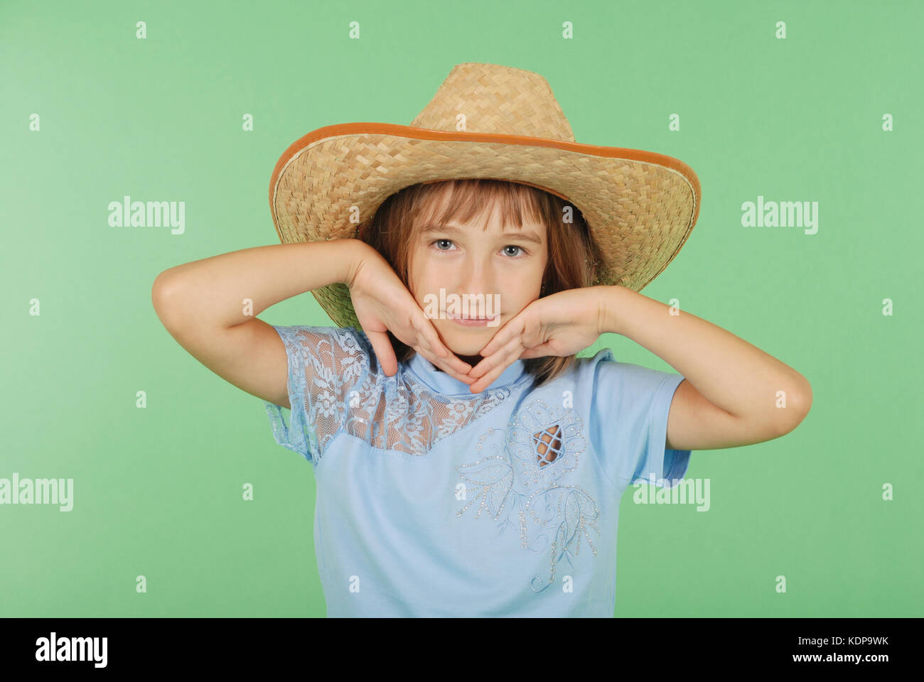 Young girl with light hair holding a straw hat in hand isolated on ...