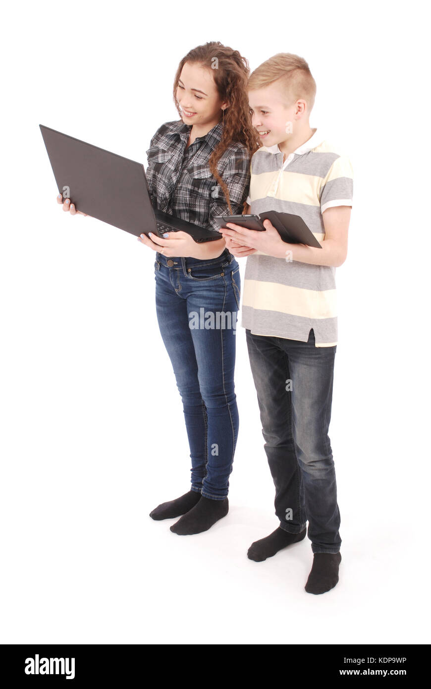 Two kids playing and surfing the web on digital tablet and laptop ...