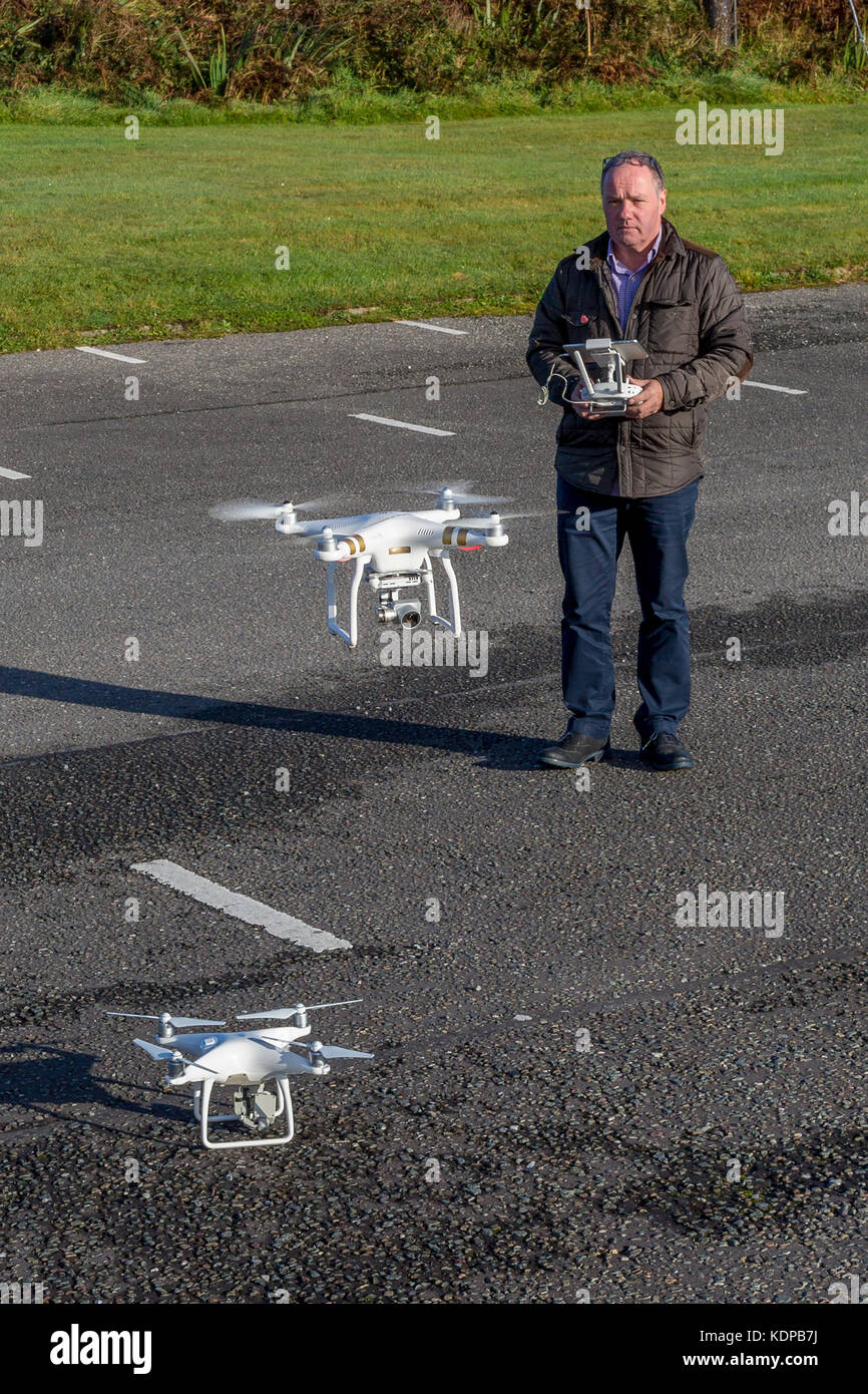 Older man flying drones in car park Stock Photo - Alamy