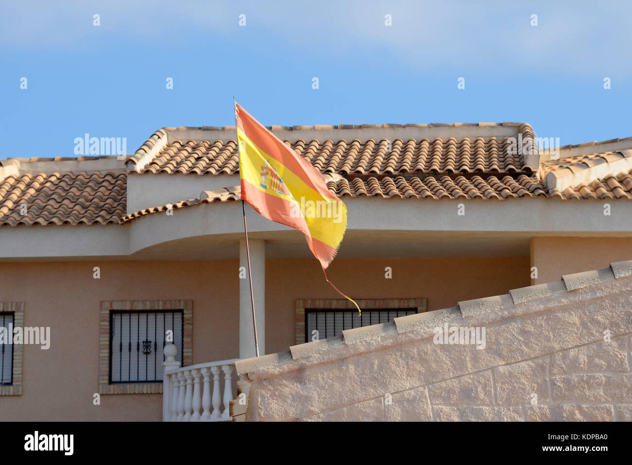 Tattered and faded Spanish flag flying outside a property in Spain ...