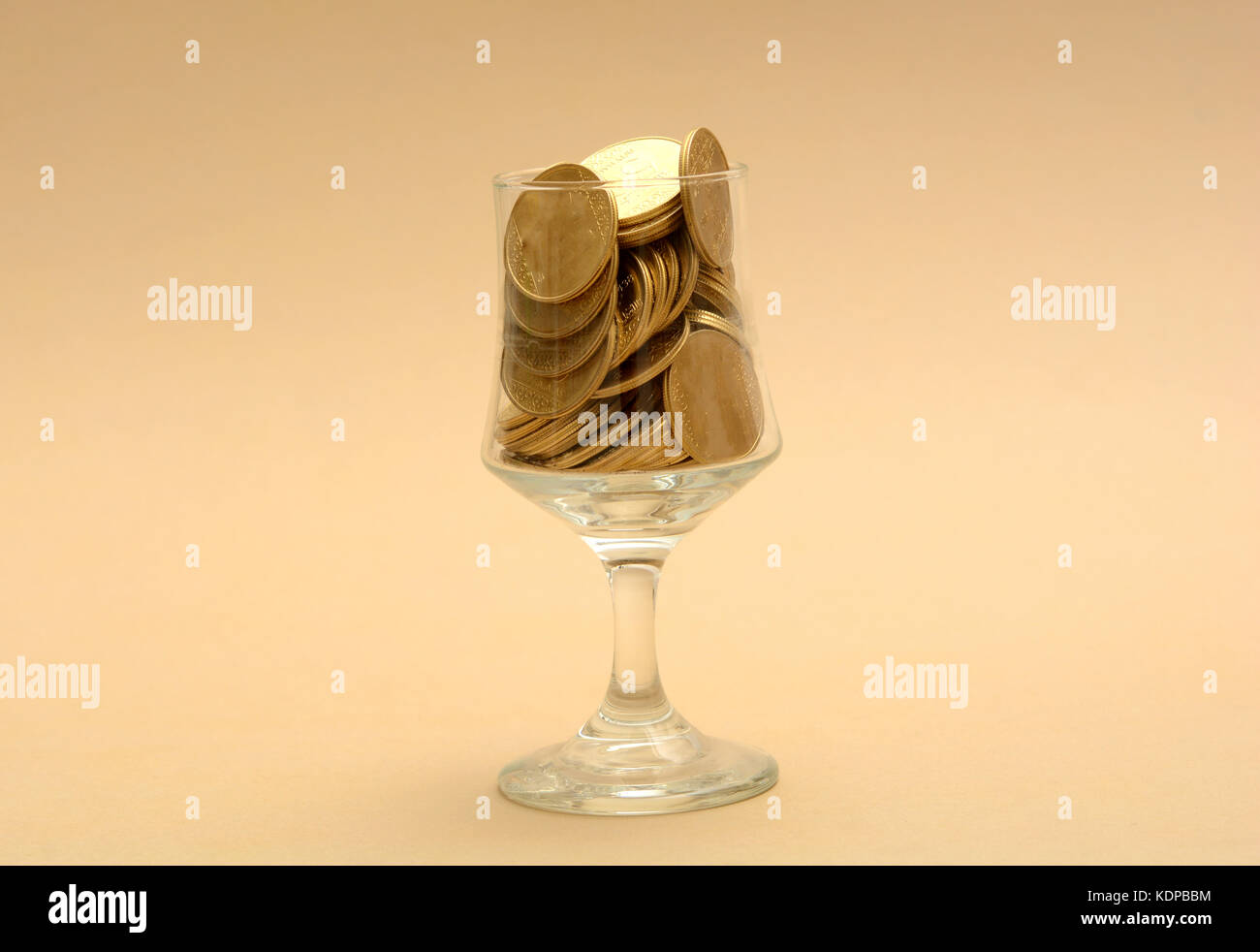 Glass full of Gold Coins - Pouring Money concept Stock Photo - Alamy