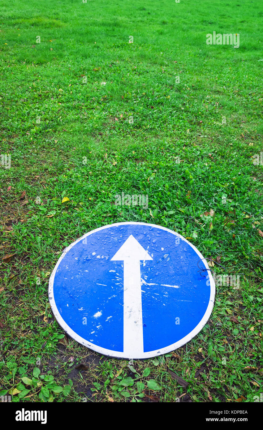 Ahead only, round blue road sign with white directional arrow lays on ...