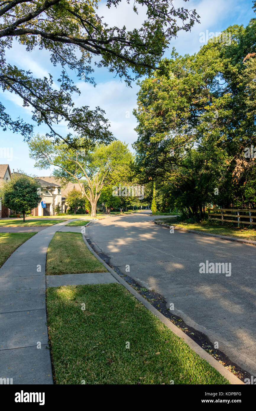 Quiet Neighborhood street with trees and fence on summer morning Stock ...