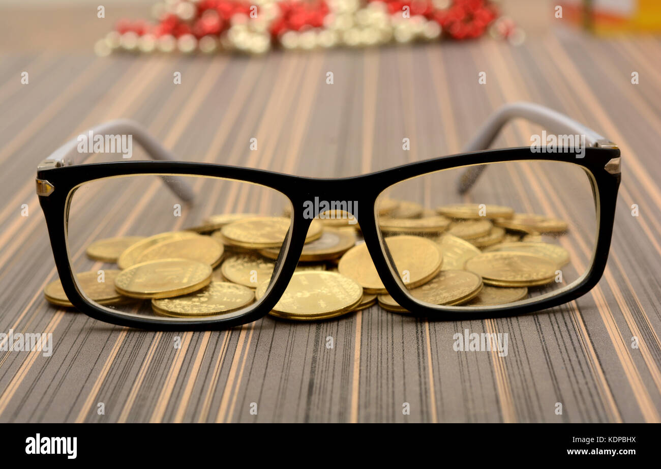 Eye Glass with gold coins - Analysis concept Stock Photo - Alamy