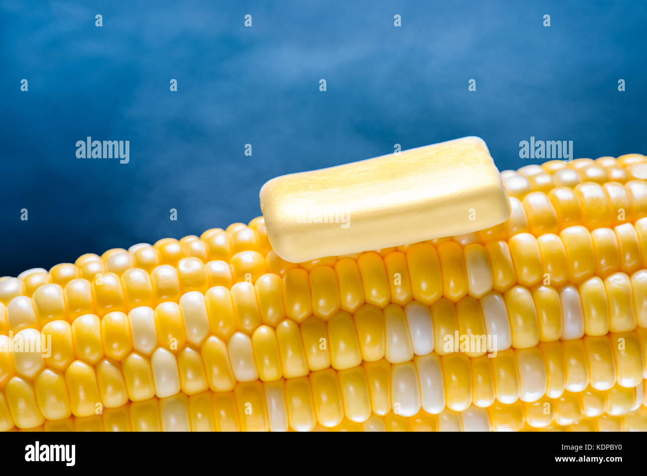 Closeup of a steaming organic corn cob with a piece of melting butter ...
