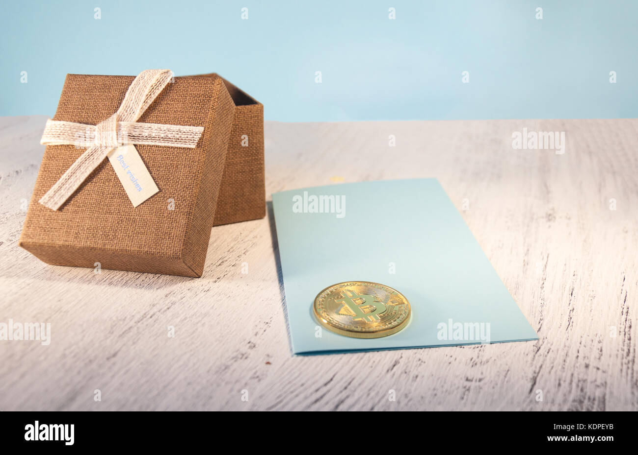 A brown gift box and a beige ribbon with a label on a light background ...