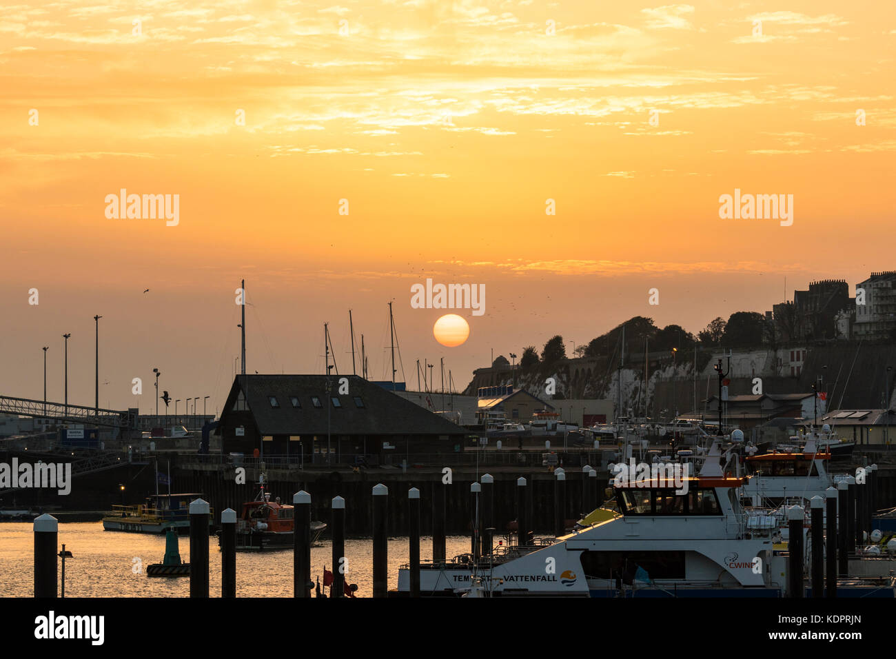 England, Ramsgate. Sunset over Ramsgate seen from the harbour. Sun is ...