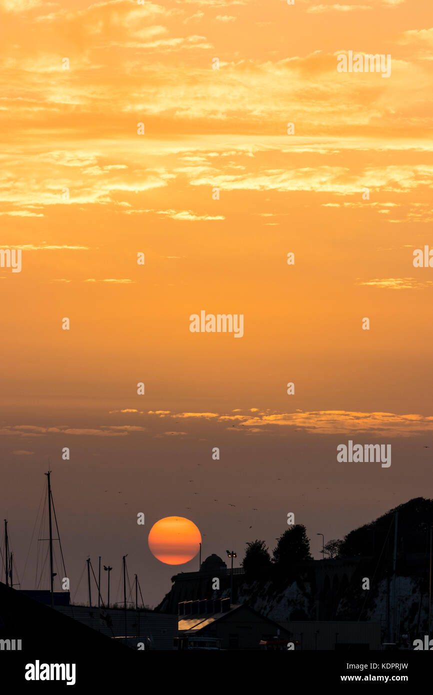 England, Ramsgate. Sunset over Ramsgate seen from the harbour. Sun is ...
