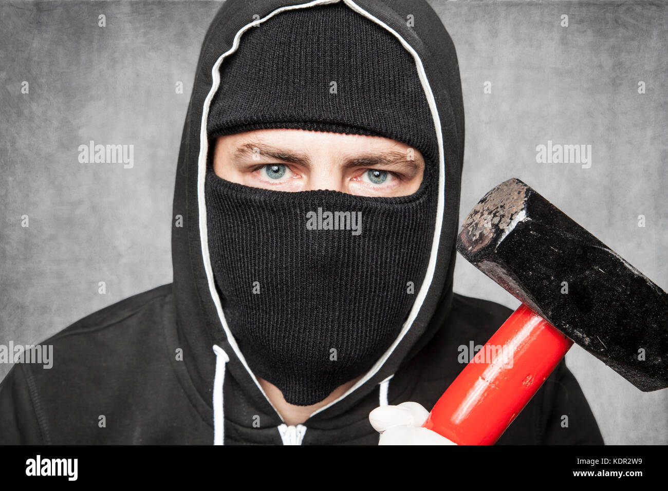 Close-up on a masked stranger, hammer in a hand Stock Photo - Alamy