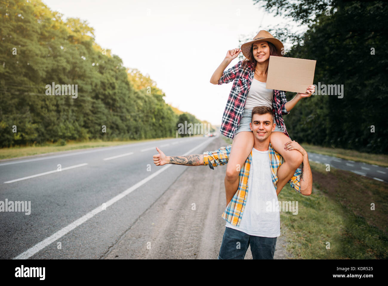 Young hitchhiking couple with empty cardboard. Hitchhike adventure of ...