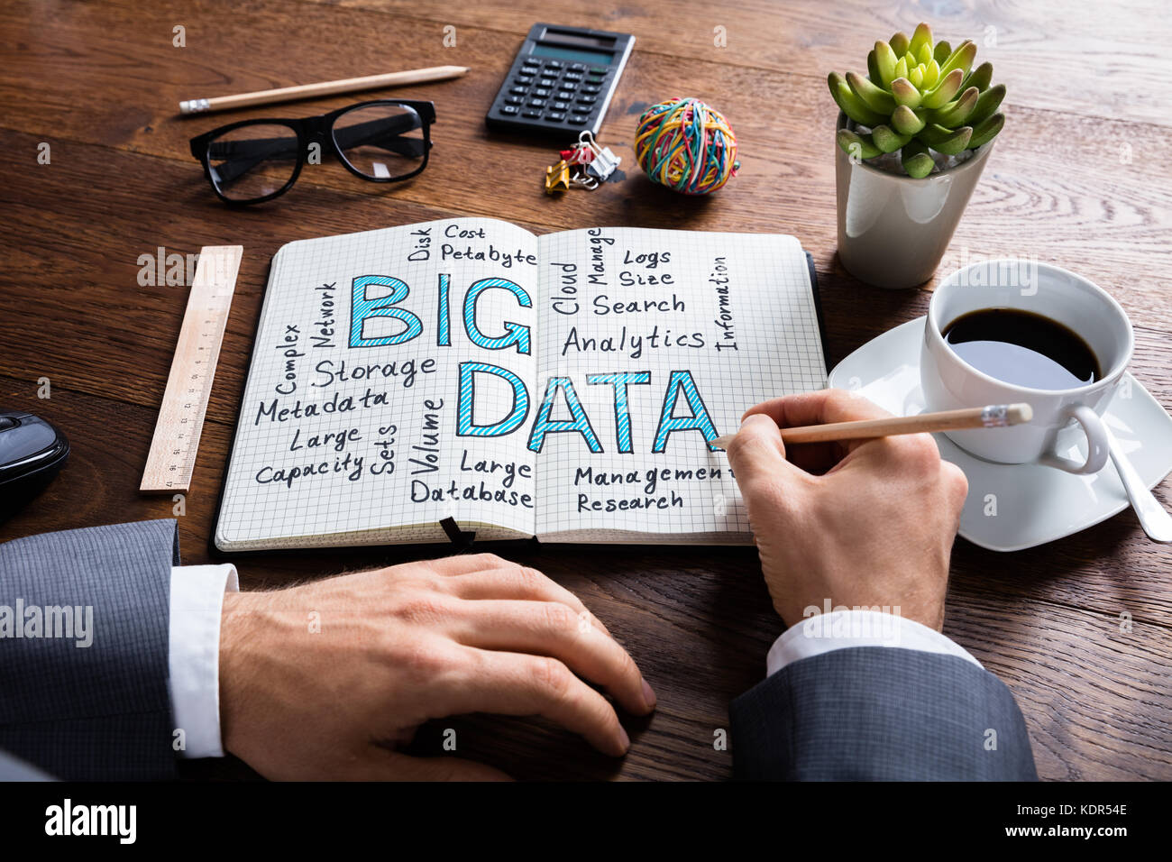 Businessman Writing On A Notebook About Big Data At Wooden Desk In ...
