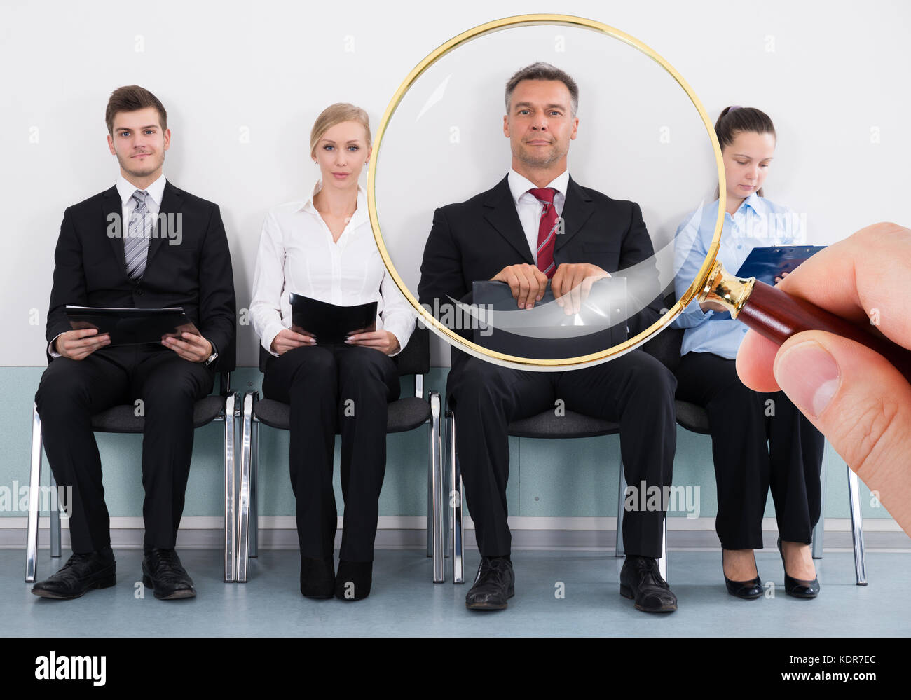 Close-up Of Person Holding Magnifying Glass On The Businessperson For ...