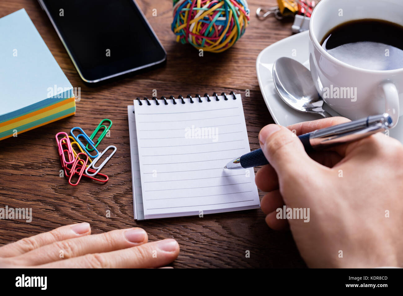 Close-up Of Person Hand Holding Pencil On Blank Notepad Near Scale And ...