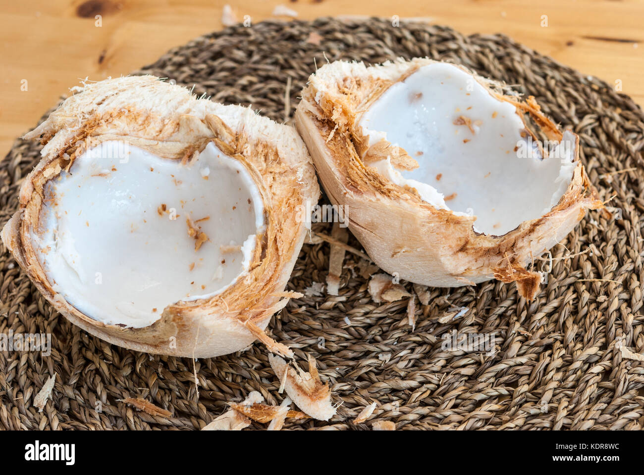 Young coconut broken in half on table in warm sunlight Stock Photo - Alamy