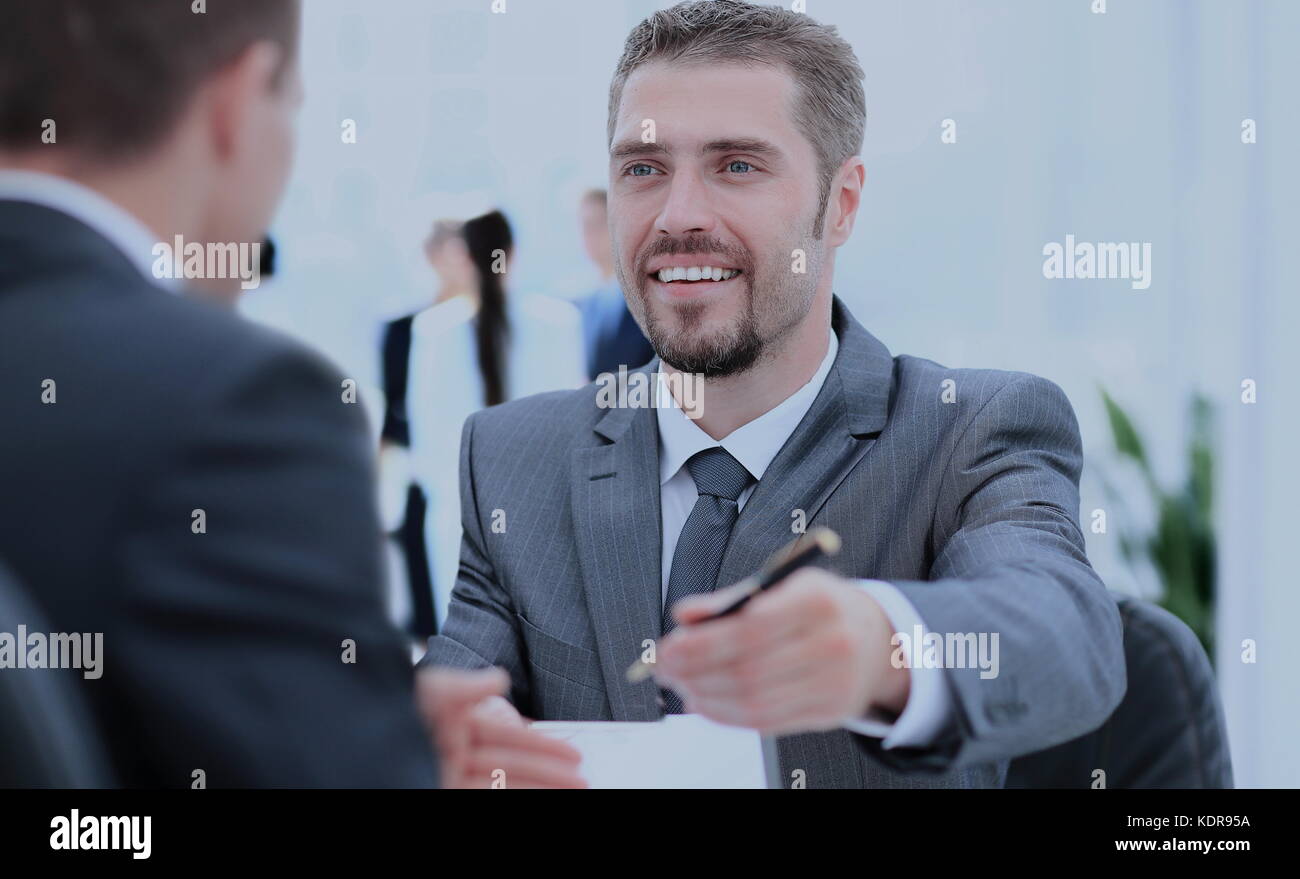 Businessman giving a pen his customer Stock Photo - Alamy