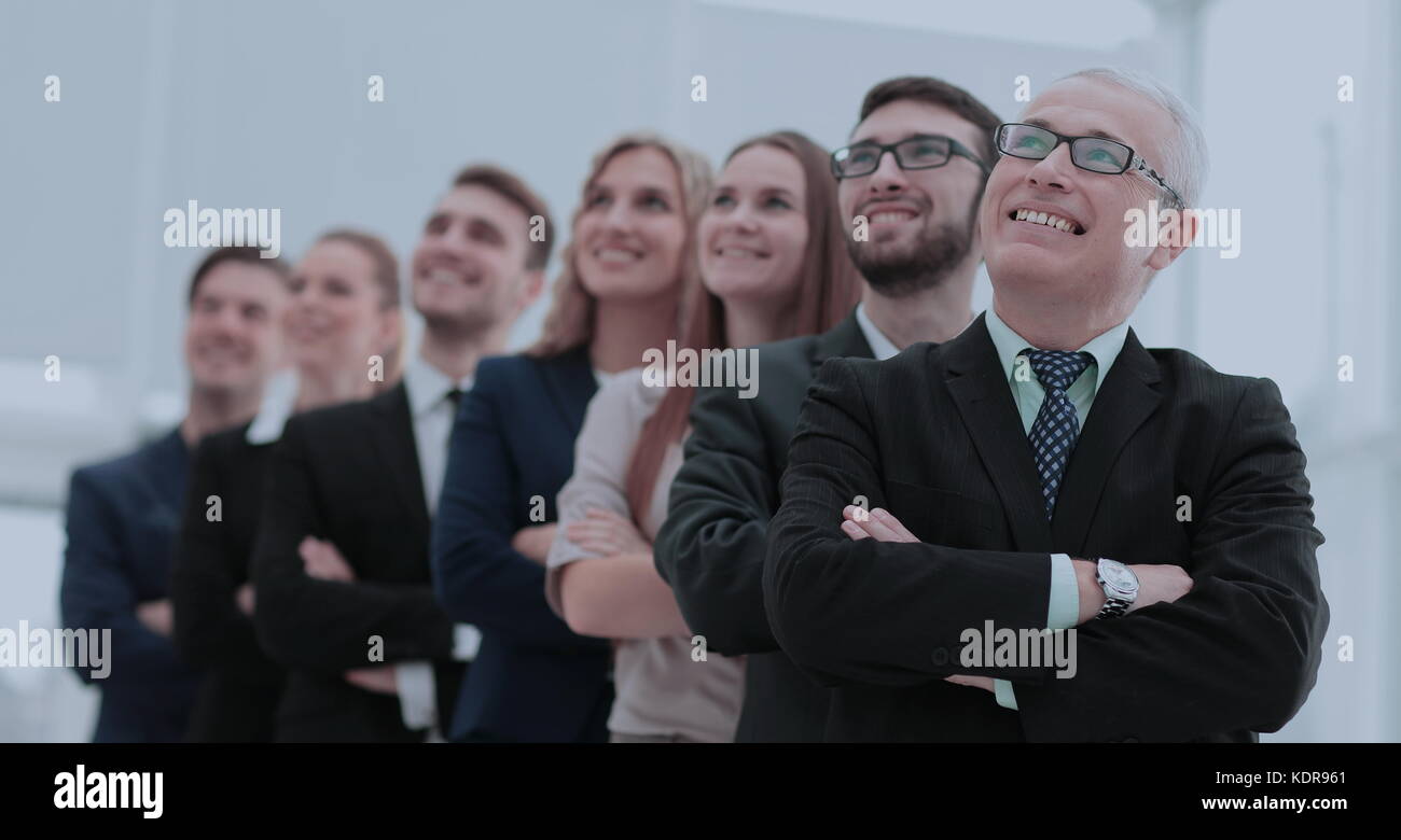 Close-up of employees of a business team standing with crossed arms ...