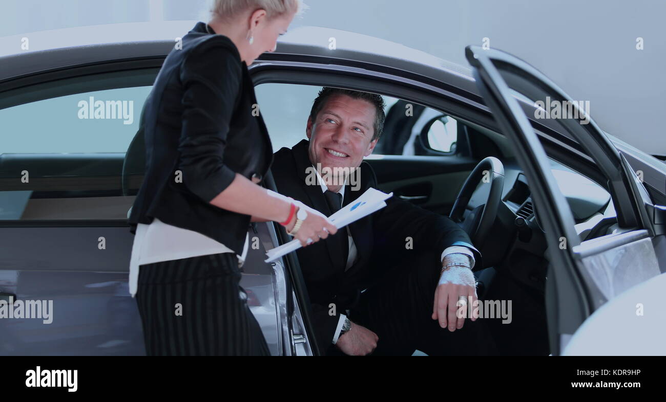 Handsome successful man buying a car at dealership Stock Photo - Alamy