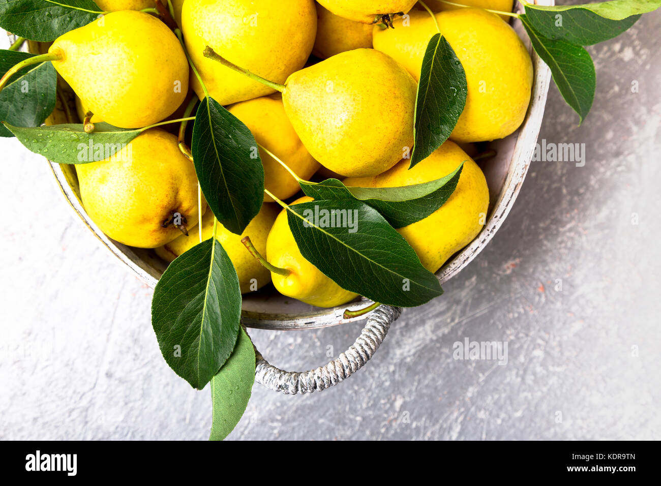 Yellow pear in grey basket in grey background. Harvest. Top view. Full ...
