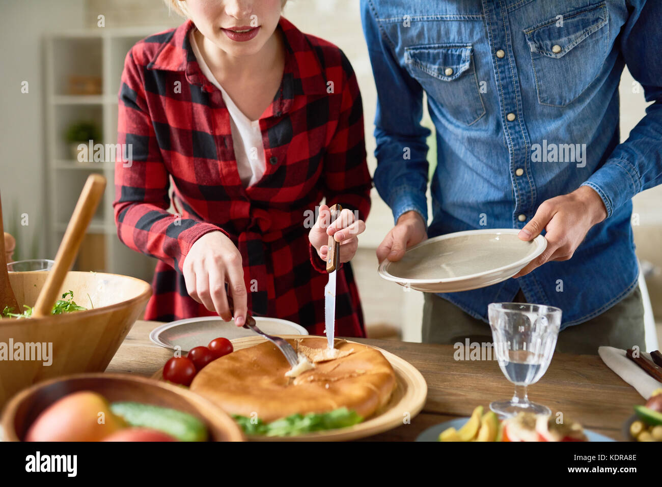 Young Couple Cutting Pie at Dinner Table Stock Photo - Alamy