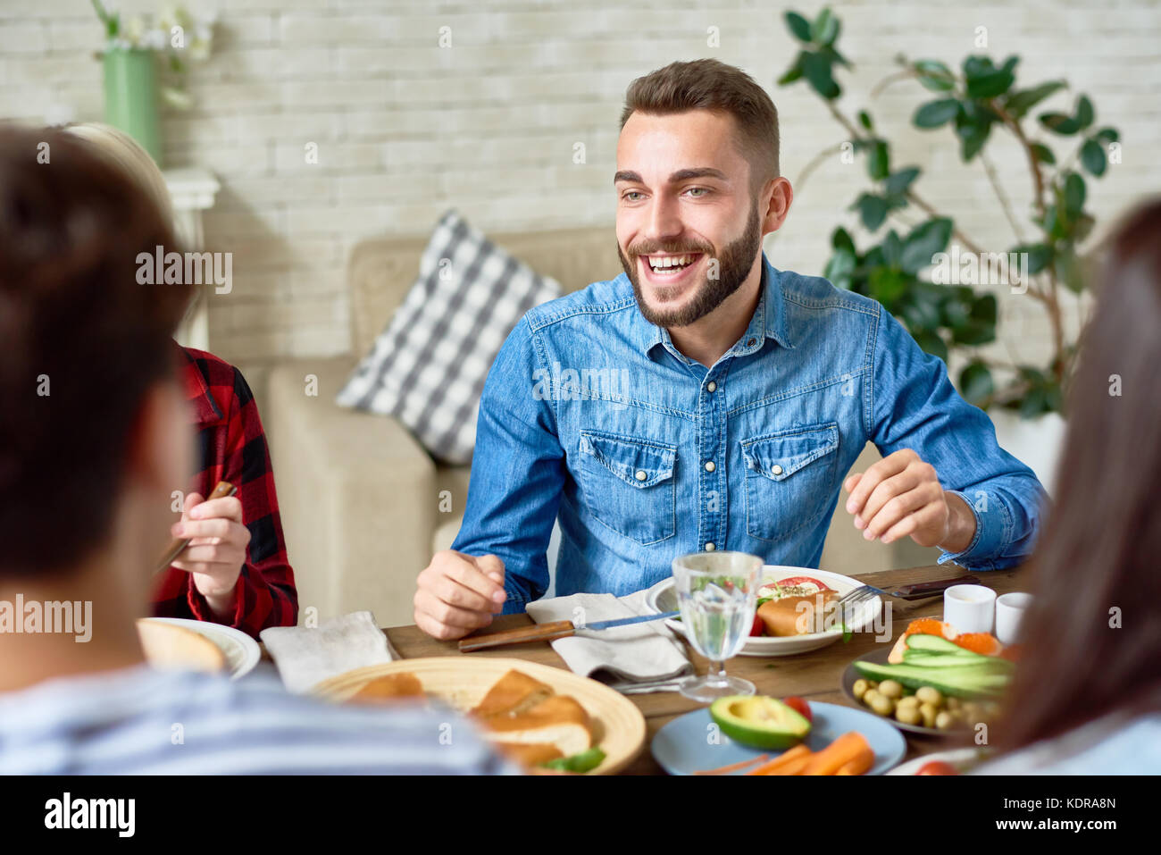 Young Man Enjoying Dinner with friends Stock Photo - Alamy