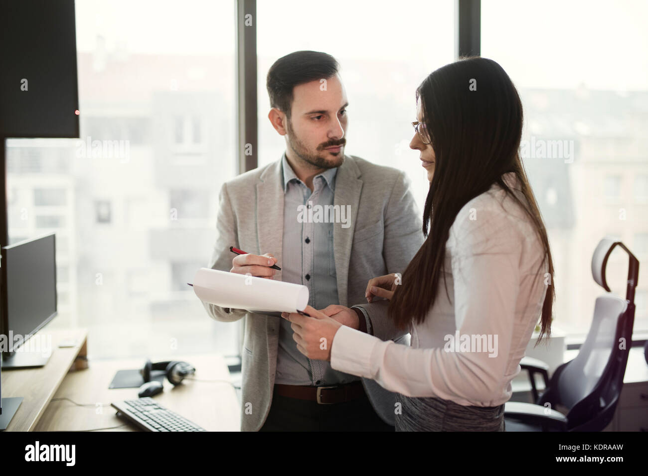 Picture of business couple discussing in office Stock Photo - Alamy