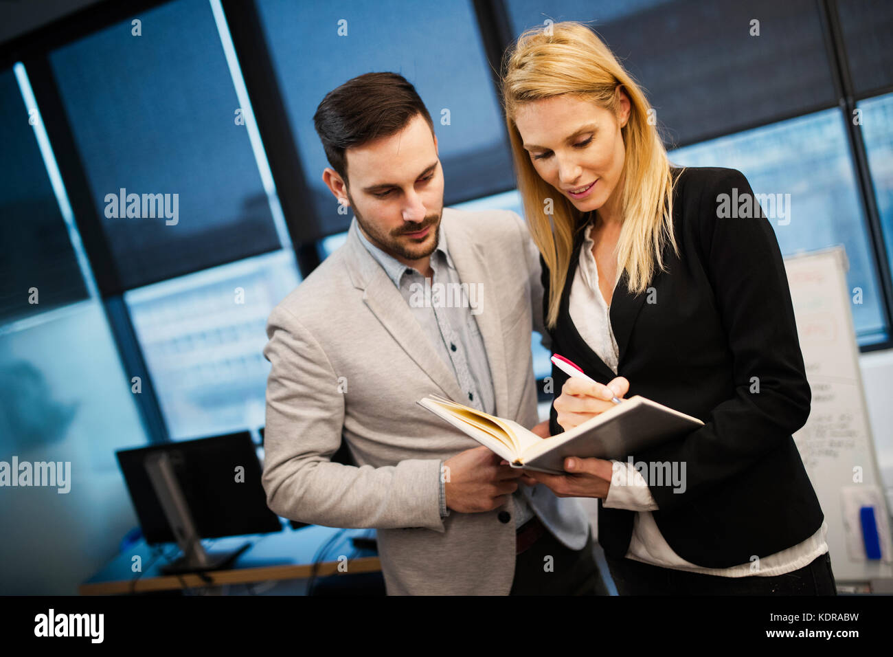 Attractive business couple having discussion in office Stock Photo - Alamy