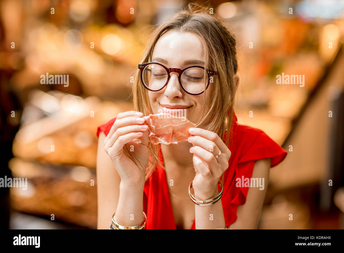 Spanish woman eating jamon at the market Stock Photo - Alamy