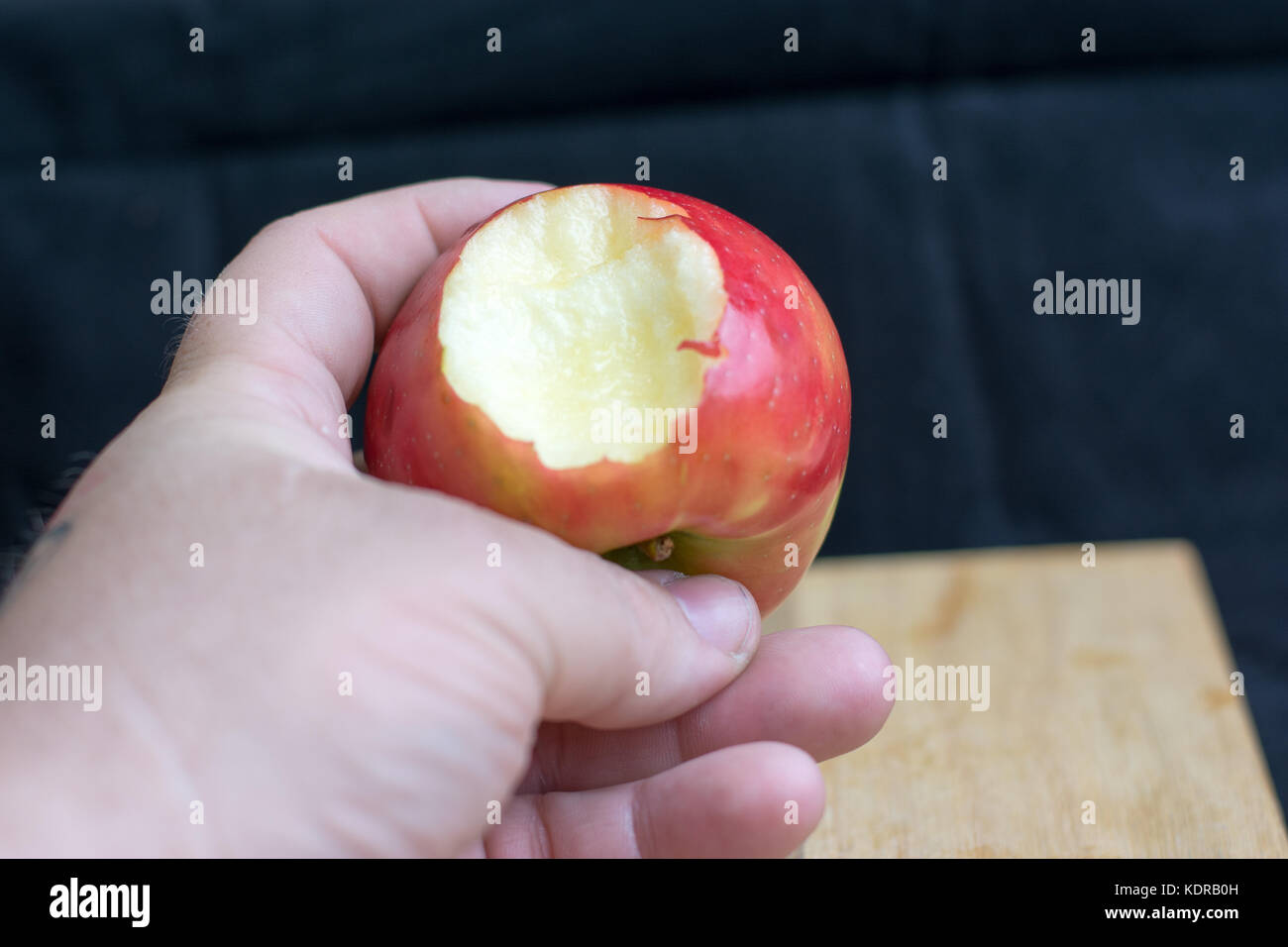 apple being held in a male hand with bite taken out of it Stock Photo ...