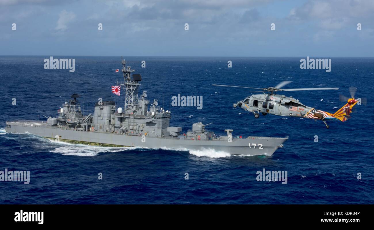 A U.S. Navy MH-60S Seahawk helicopter flies over the Japanese Maritime ...