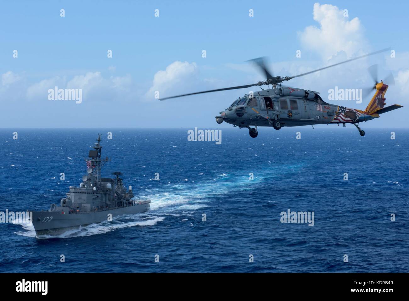 A U.S. Navy MH-60S Seahawk helicopter flies over the Japanese Maritime ...