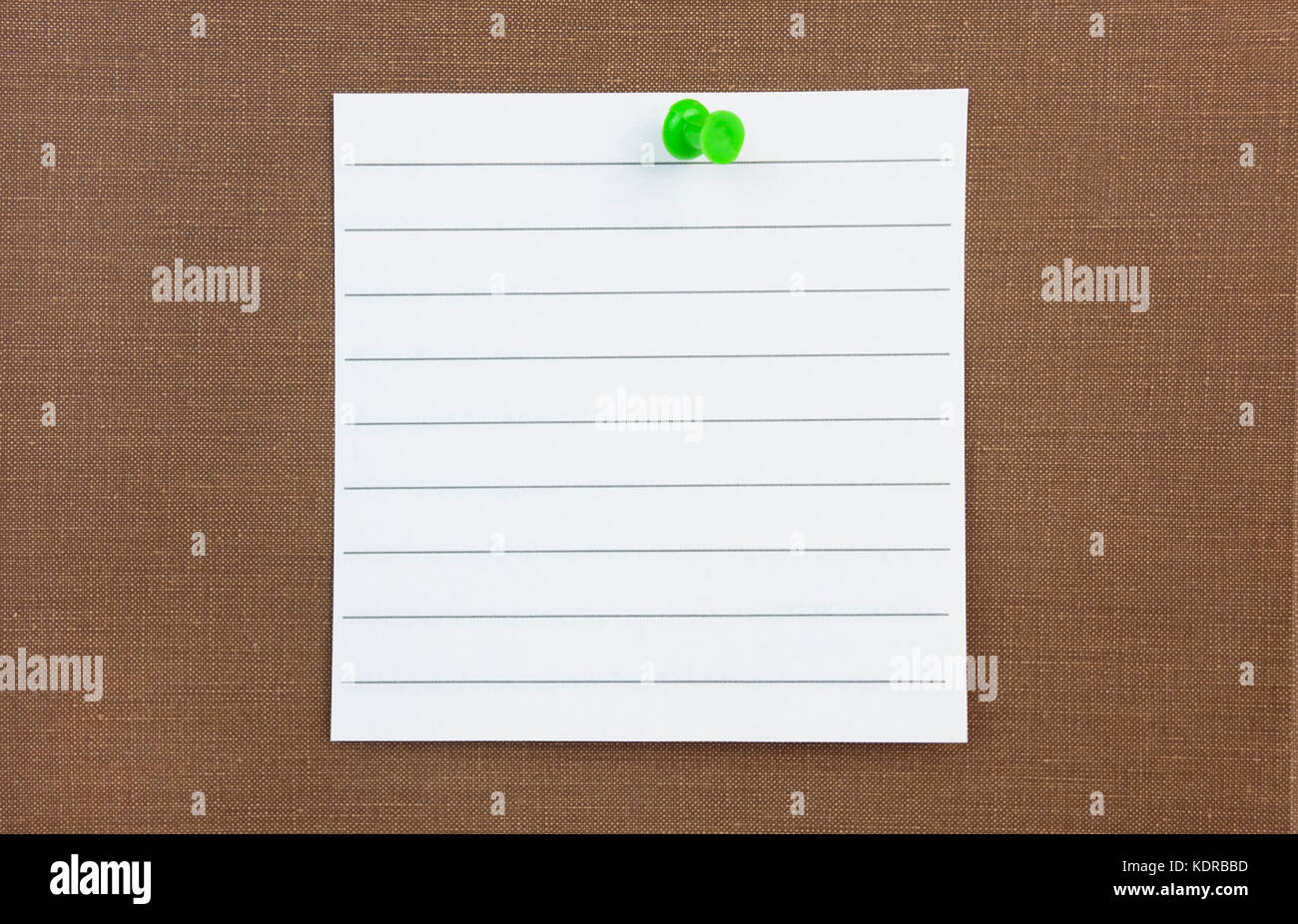 Lined blank note with green pushpin on brown fabric background Stock ...