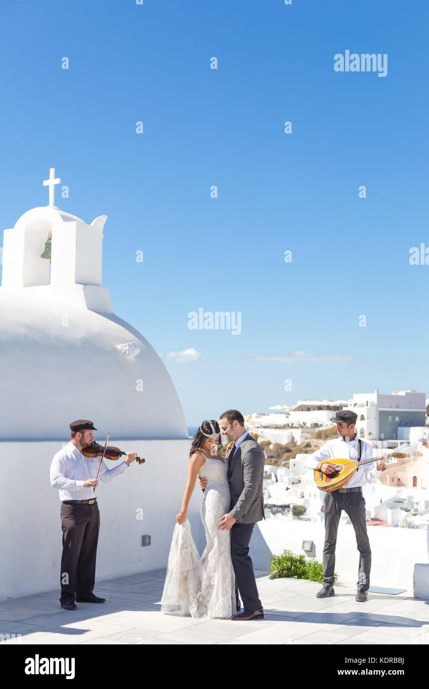 Bride and groom dansing on wedding ceremony on Santorini island, Greece ...