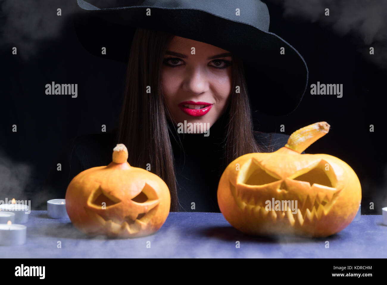 Halloween Witch With A Magic Pumpkin Beautiful Young Woman In Witches Hat And Costume Holding
