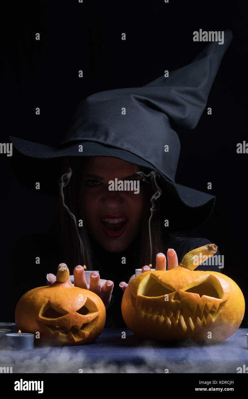 Halloween Witch With A Magic Pumpkin Beautiful Young Woman In Witches Hat And Costume Holding